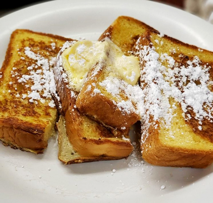 French toast that doesn't need a passport to impress. That dusting of powdered sugar is like morning snow on perfectly caramelized bread mountains.