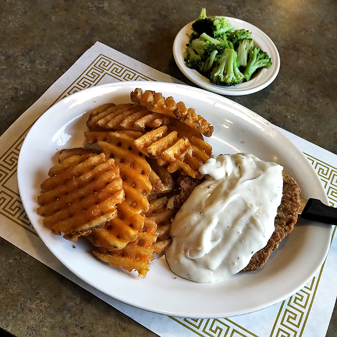 Country fried steak with waffle fries&mdash;where crispy meets creamy in a dance as old as time. That gravy isn't just a topping; it's liquid comfort.