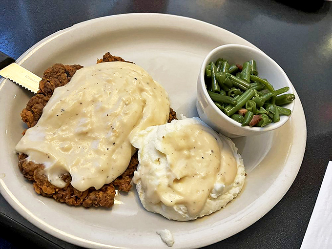 Country fried steak smothered in creamy gravy with a side of green beans&mdash;proof that heaven exists on a plate.