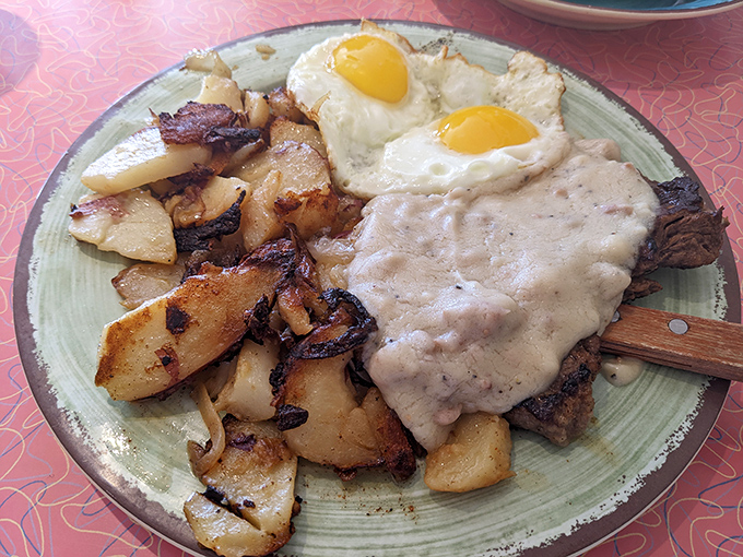 Country fried steak smothered in gravy with sunny-side eggs. A plate that says "nap required later" but worth every delicious, indulgent bite.