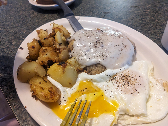 Breakfast nirvana: golden potatoes, perfectly runny eggs, and gravy that could make a vegetarian question their life choices.