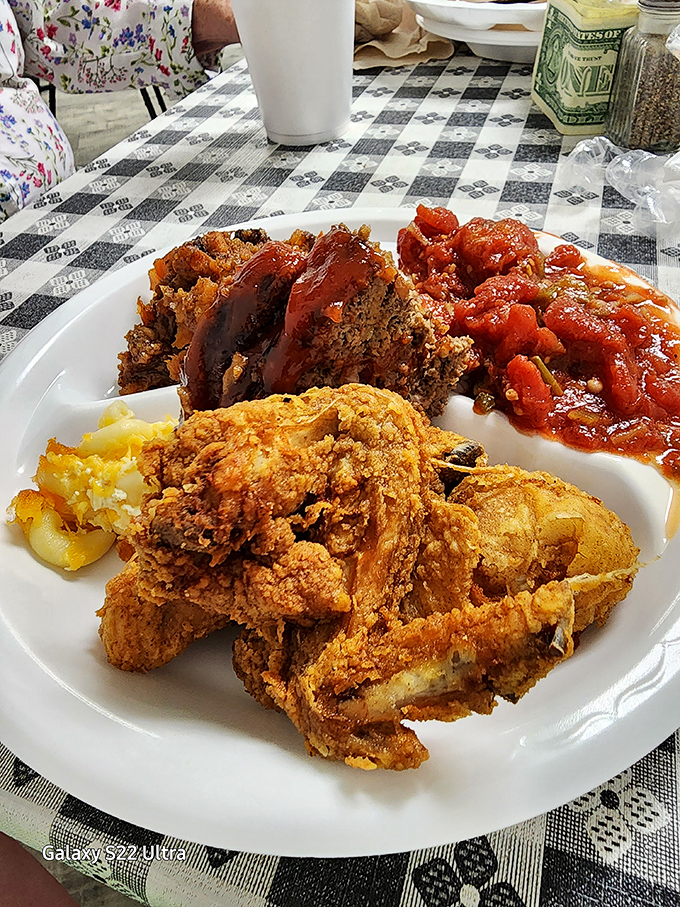 Fried chicken with a crust that shatters like glass, revealing juicy meat within. The stewed tomatoes alongside might be the unsung hero here.