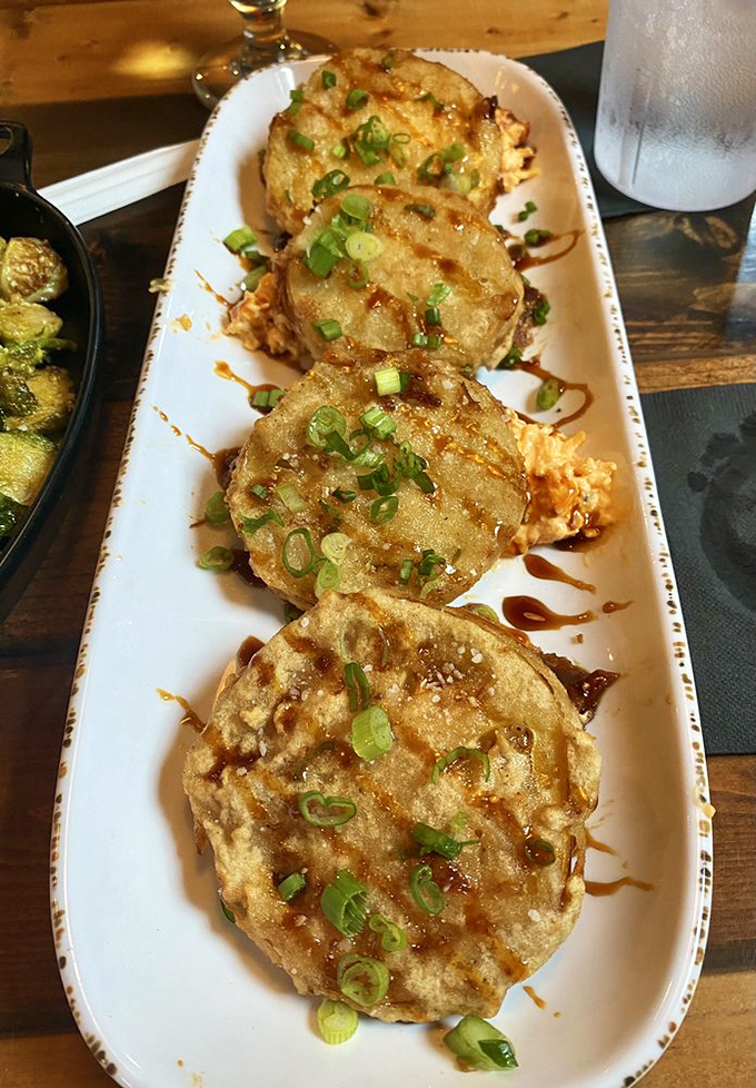 The fried green tomatoes&mdash;our article's stars&mdash;arrive golden and crispy, topped with green onions and a drizzle that makes them irresistible.