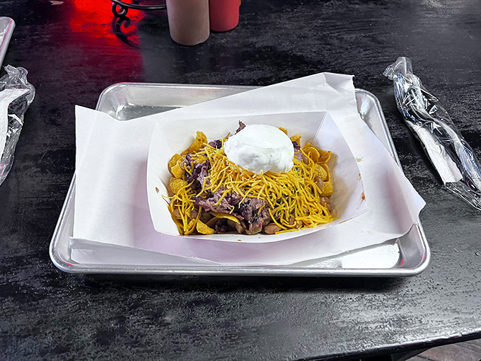 Frito Pie&mdash;where corn chips meet barbecue in a marriage blessed by the gods of comfort food. Topped with cheese and sour cream because why stop at merely delicious?