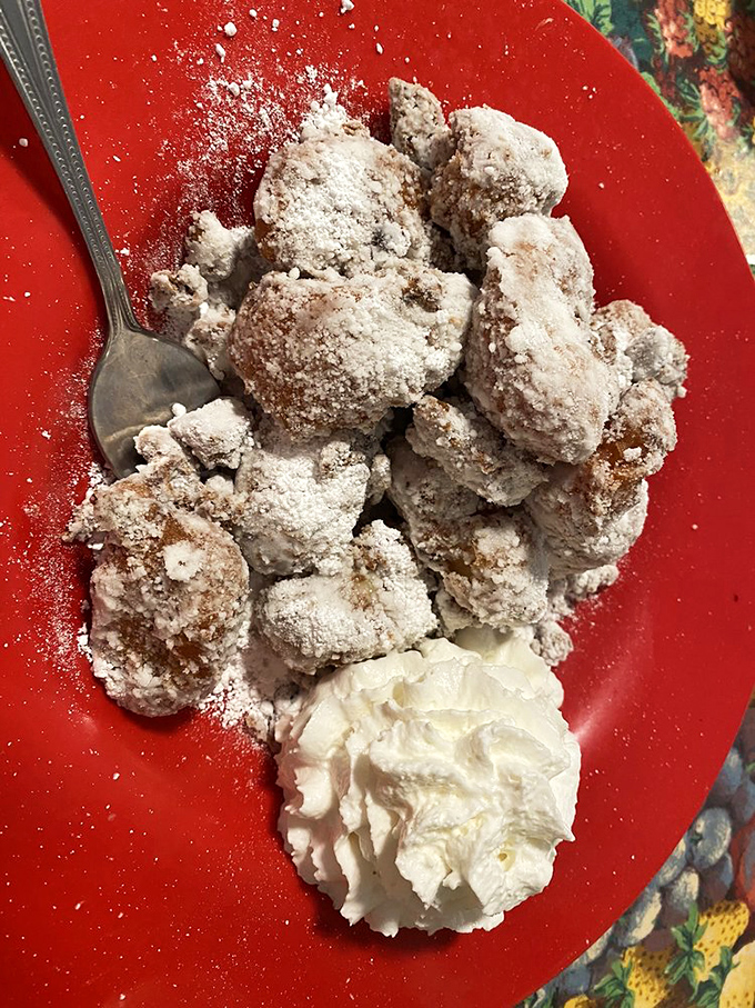Powdered sugar snowfall on golden fritter mountains. One bite and you'll understand why people drive across county lines for these beauties.