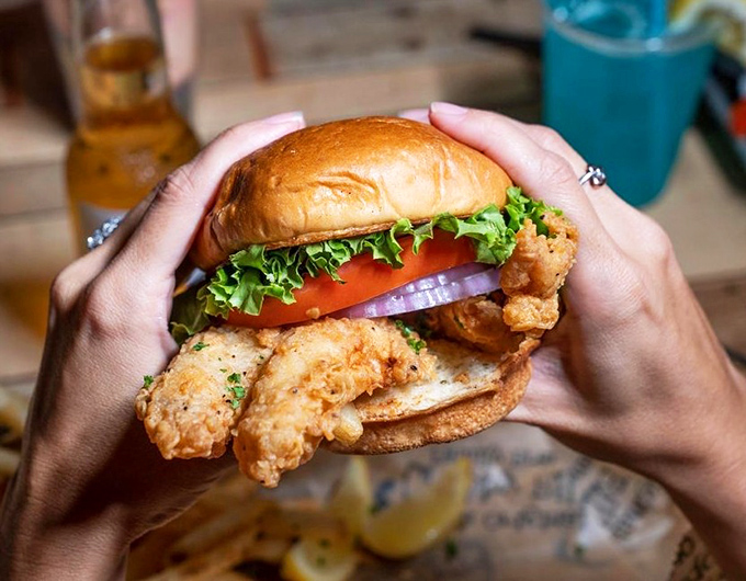 This fried grouper sandwich requires a two-handed commitment and possibly a post-meal nap. Worth every delicious, messy bite.