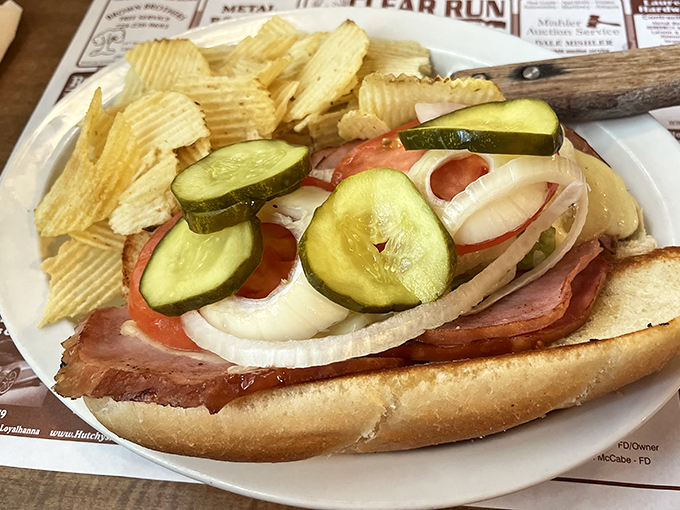 This isn't just a sandwich; it's an engineering marvel. Layers of ham, fresh veggies, and pickles create the perfect balance of salt, crunch, and tang.