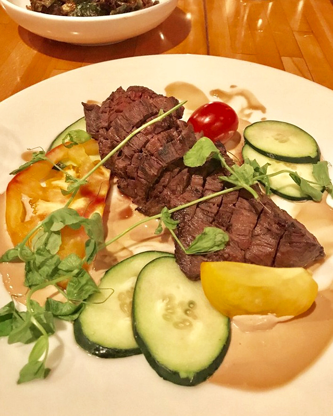 This hanger steak isn't just cooked&mdash;it's respected. Perfectly sliced, surrounded by fresh vegetables, it's the bovine equivalent of a standing ovation.