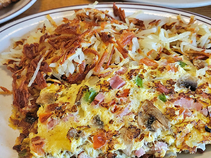 This isn't just breakfast, it's edible architecture. Layers of eggs, ham, peppers, and perfectly crisped hash browns create the morning masterpiece we all deserve.