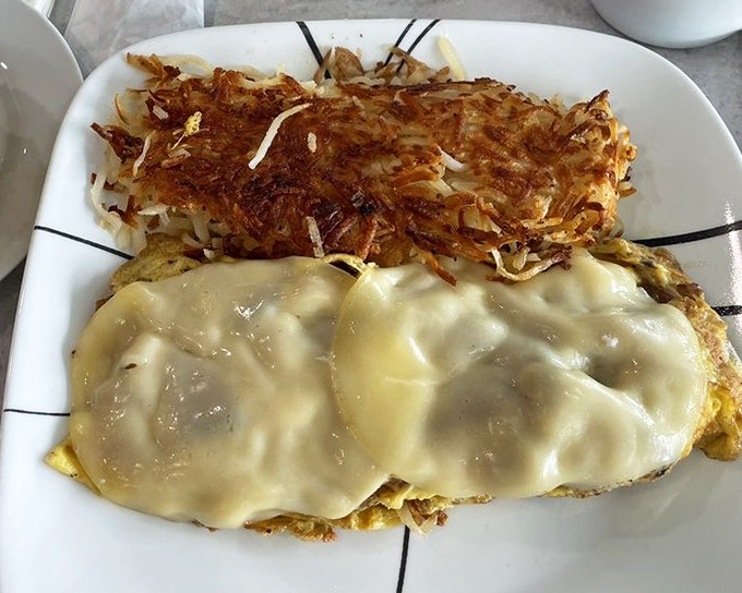 This isn't just a cheese omelet; it's a masterpiece of morning indulgence with hash browns crisped to golden perfection.