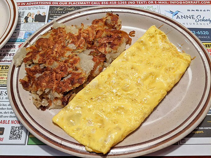 A perfectly executed omelet alongside hash browns so crispy they practically announce their arrival with a fanfare of deliciousness.