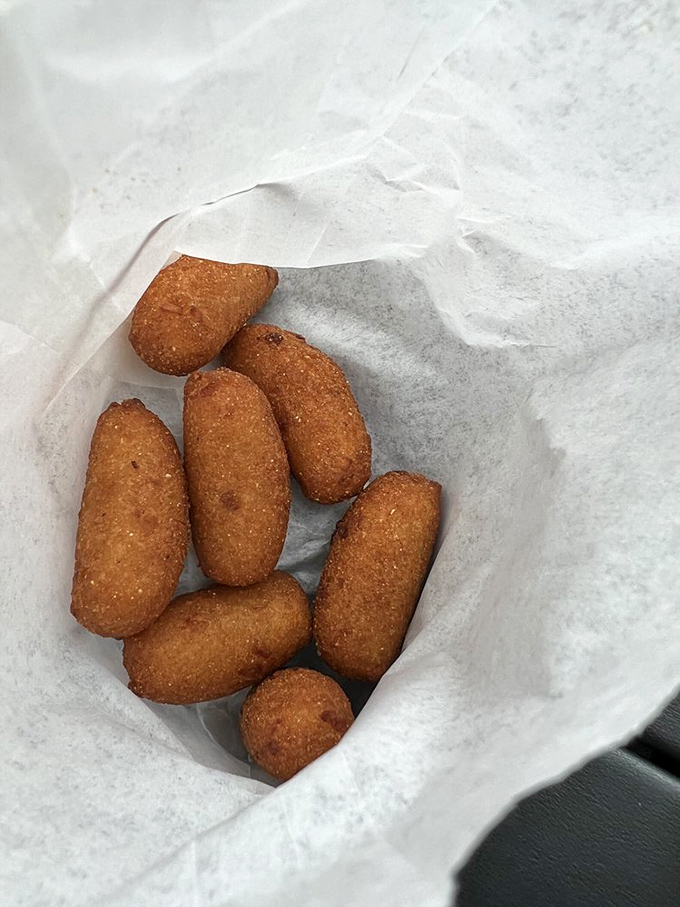 Golden-brown hush puppies that crunch like nature's perfect snack. These cornmeal gems are worth the trip alone.