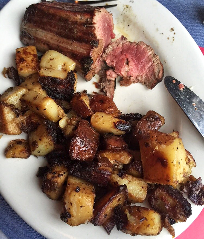 The steak arrives medium-rare with a side of home fries that have clearly been introduced to heat with proper respect and admiration.