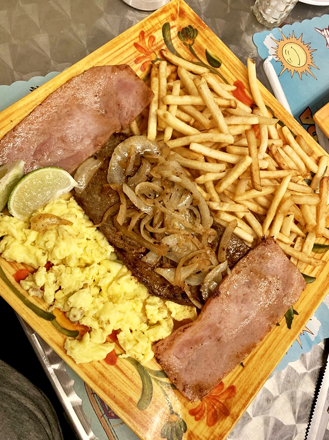 Breakfast Miami-style: where eggs, ham, and fries join forces on colorful dishware to create morning magic that puts your cereal routine to shame.