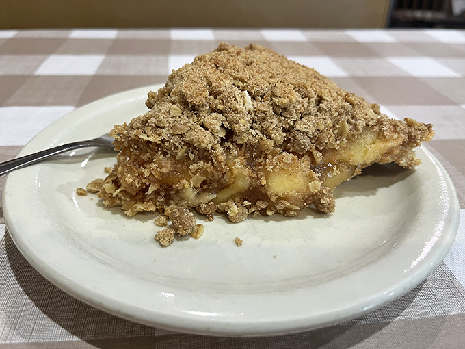 Apple pie with a crumb topping so perfect it should be in the Smithsonian. The kind of dessert that makes you consider ordering a second slice before finishing the first.