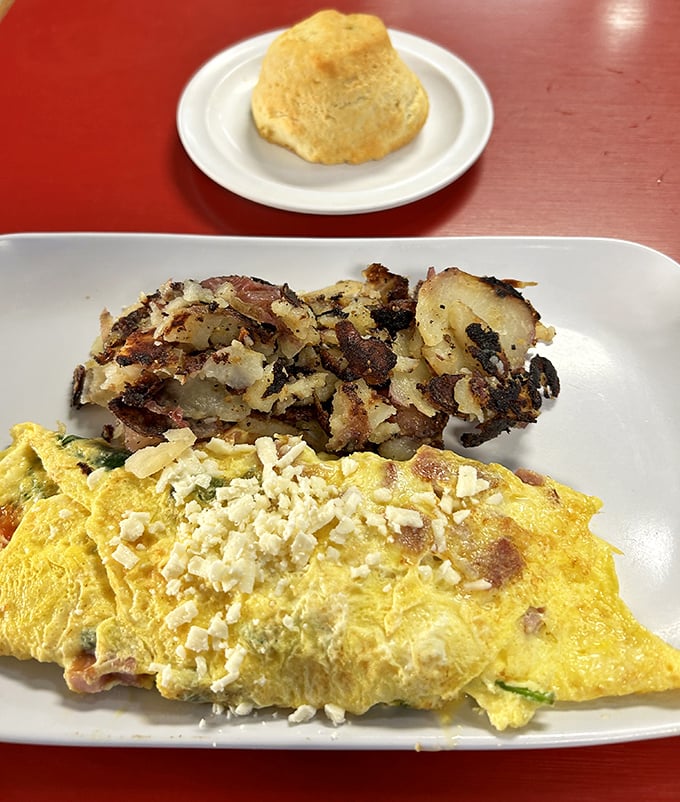 A golden-brown biscuit stands sentinel over a perfect omelet and crispy potatoes &ndash; the breakfast trinity that launches a thousand good days.