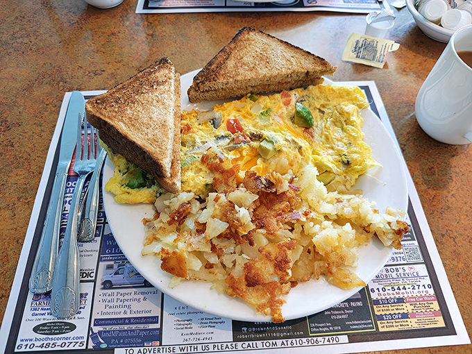 Breakfast nirvana: a veggie-packed omelet alongside crispy home fries and perfectly toasted bread&mdash;the holy trinity of morning satisfaction.
