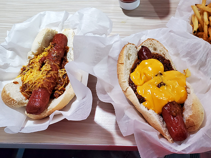 Hot dogs elevated to art form &ndash; one classic with chili and cheese, one boldly dressed with mustard. Comfort food that speaks a universal language.