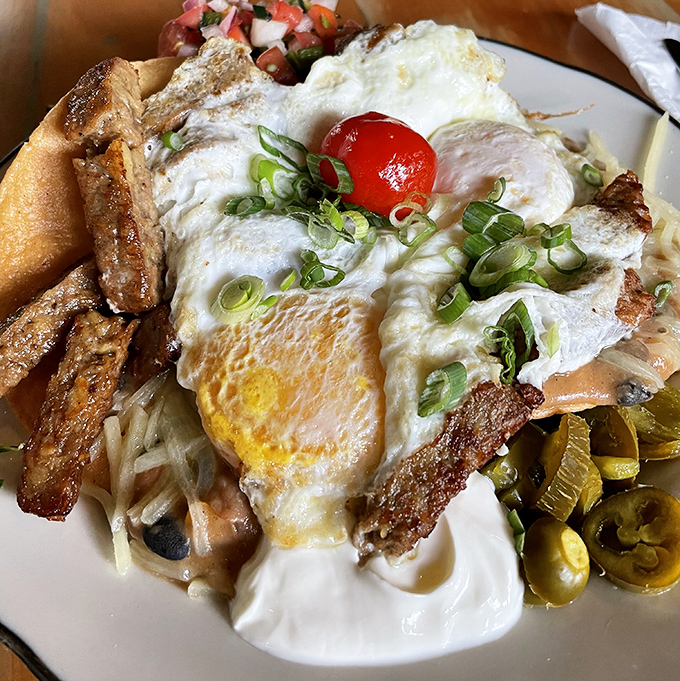 Eggs that know exactly what they're doing, perched atop a mountain of hash browns with jalapeños standing guard. Breakfast with ambition.