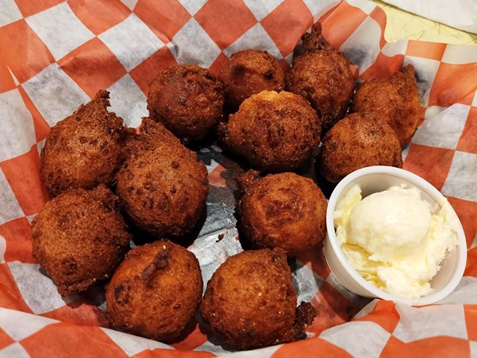These hush puppies aren't just side dishes, they're little orbs of cornmeal joy, fried to a deep amber and served with a dollop of butter that slowly melts into liquid gold.