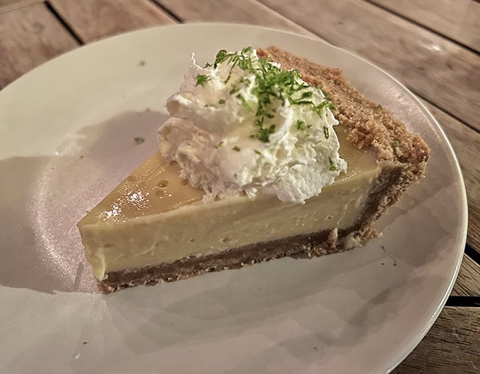 The key lime pie arrives with a cloud of whipped cream and a sprinkle of zest—tangy, sweet, and utterly impossible to share.