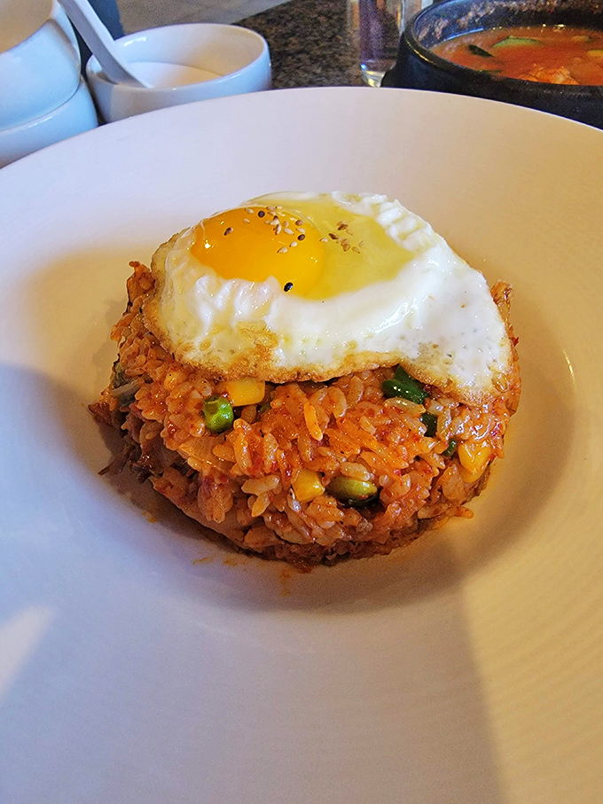 This isn't just kimchi fried rice; it's a spicy, savory masterpiece crowned with a sunny-side-up egg that's just waiting for that perfect yolk-breaking moment.