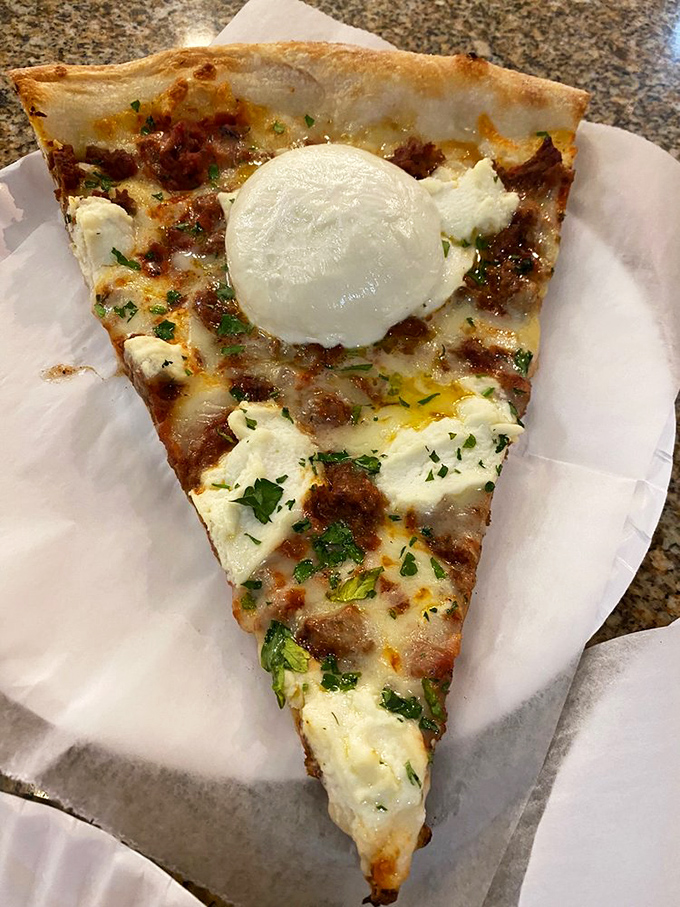 A slice topped with fresh mozzarella that stretches like the truth when politicians discuss their diets. Pure, indulgent comfort on a paper plate. 