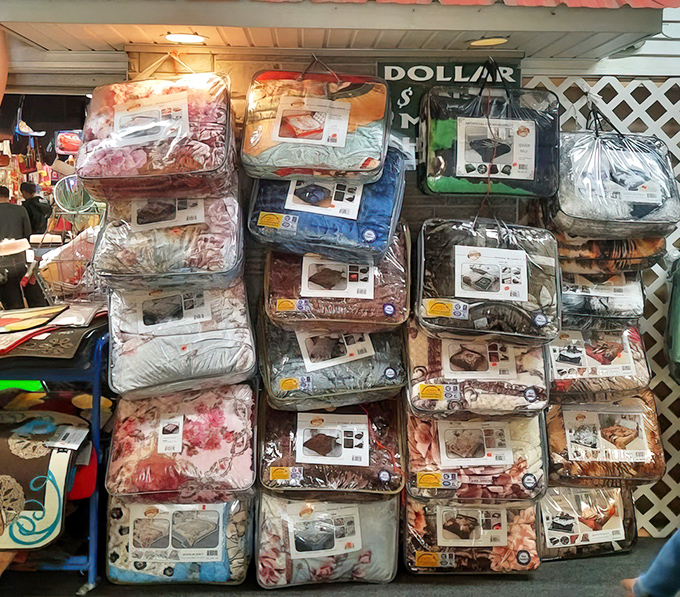 Bedding sets stacked like colorful dreams, waiting to transform someone's bedroom into a cozy sanctuary retreat.