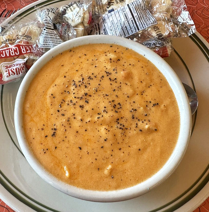 The lobster bisque arrives like a sunset in a bowl, velvety and rich, with each spoonful delivering a warm hug to your soul.