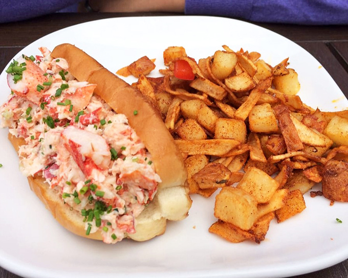 A lobster roll that doesn't skimp on the good stuff. That heap of sweet meat is having a reunion party with those perfectly golden home fries.