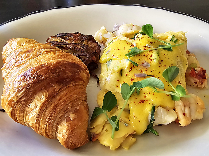 Brunch reaches new heights with this golden croissant alongside eggs that have clearly been on better terms with butter than my cardiologist would approve.