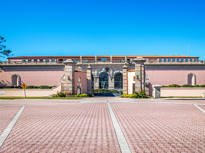 The Ringling Museum's entrance gate stands like a pink-hued invitation to another era, where circus royalty once lived large.