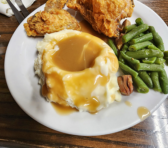 Mashed potatoes cradling a lake of gravy, flanked by crispy fried chicken and green beans – the holy trinity of heartland dining.