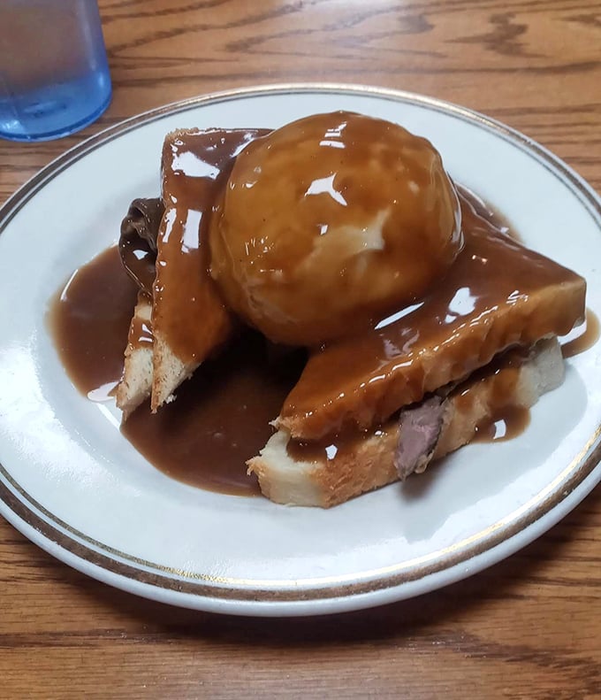 Gravity-defying gravy cascades over homestyle meatloaf and bread. This isn't a meal; it's a warm hug on a plate.