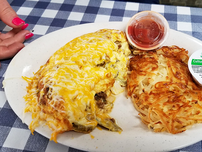 An omelet that's wearing more cheese than I wore flannel in the '90s, paired with hash browns that achieve the perfect crisp-to-tender ratio.