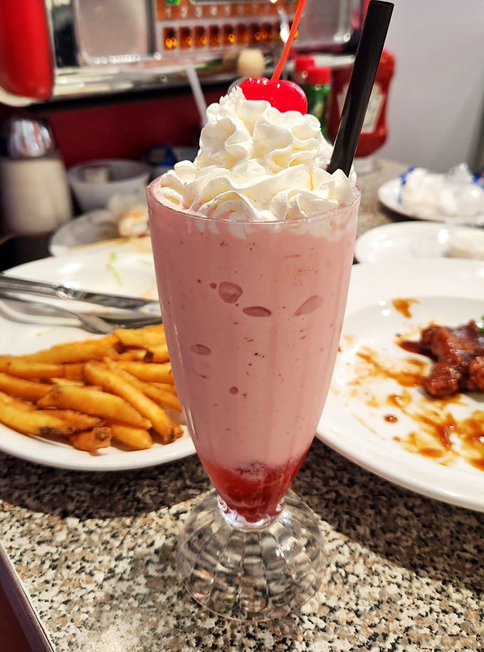 This strawberry milkshake isn't just a drink, it's a tower of dairy delight topped with enough whipped cream to make your cardiologist wince.