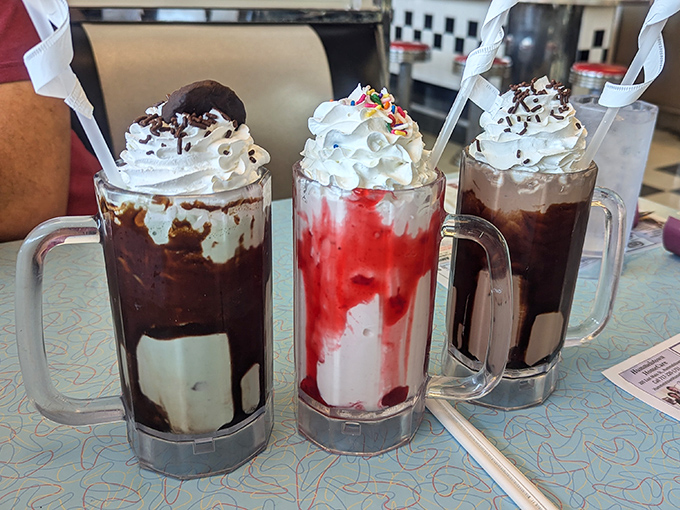 The holy trinity of milkshakes: chocolate decadence, strawberry dream, and what appears to be a cookies-and-cream masterpiece. Straws at the ready, folks!