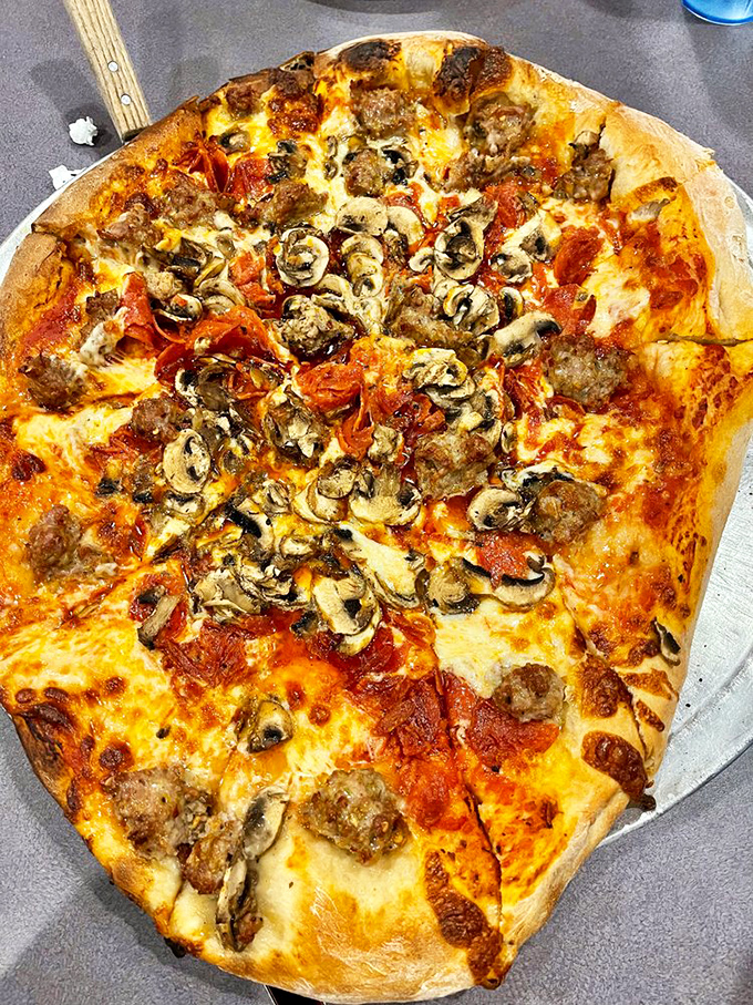 The mushroom-sausage-pepperoni trifecta creates a pizza so loaded, it requires strategic planning just to pick up a slice.