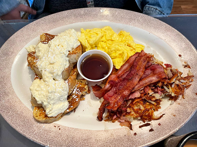 French toast smothered in creamy goodness, with eggs and bacon standing guard. The breakfast trinity that makes mornings worth facing.