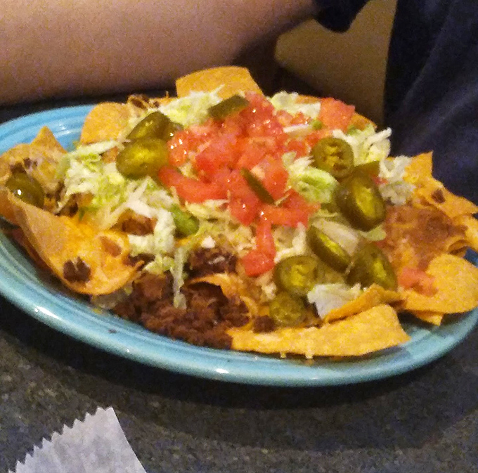 These nachos aren't just a snack; they're a topographical masterpiece of cheese, jalape&ntilde;os, and happiness that demands to be explored.