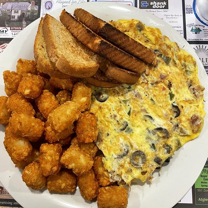 That omelet could feed a small village, paired with tater tots that understand crispy is a lifestyle choice.