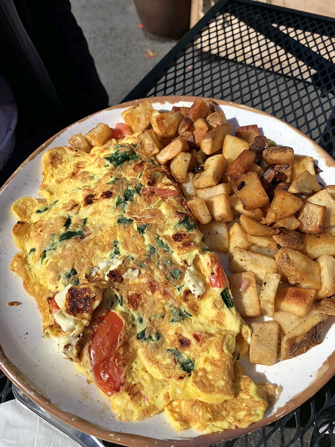 This isn't just any omelet—it's a masterclass in egg architecture, with perfectly caramelized edges and home fries that could make a potato farmer weep with joy.