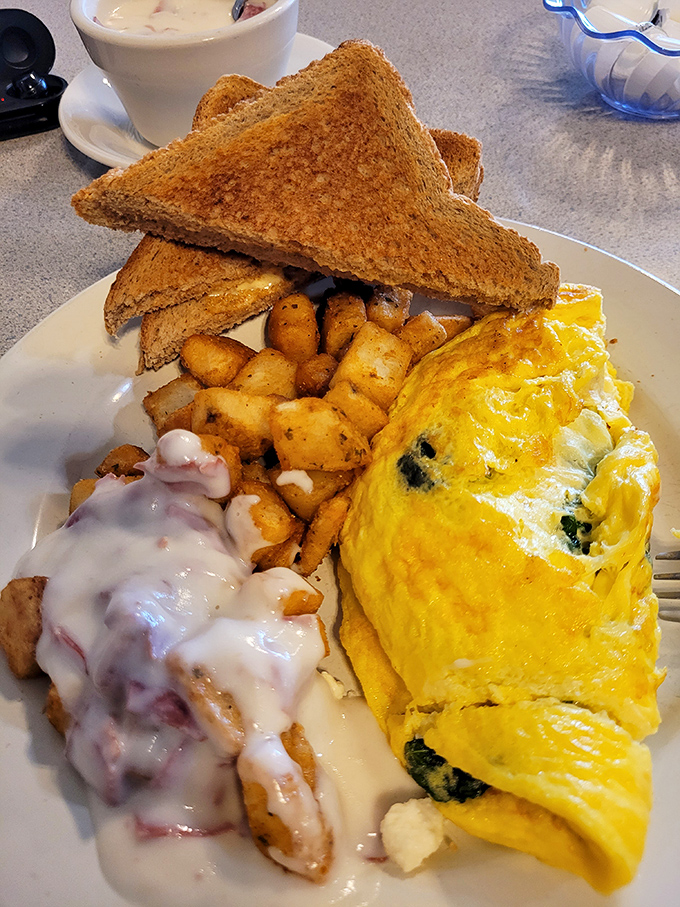 Breakfast harmony achieved: a fluffy omelet, perfectly crisped home fries, and toast&mdash;the holy trinity of morning satisfaction.