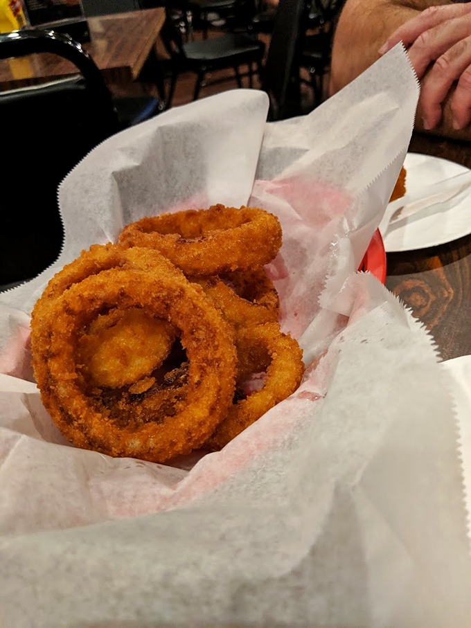 Golden-brown onion rings that shatter with each bite, revealing sweet, tender onion within. The paper basket? Just a formality between you and happiness.