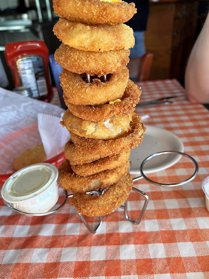 These aren't just onion rings &ndash; they're crispy golden halos stacked like the world's most delicious Jenga game. The dipping sauce is liquid gold.