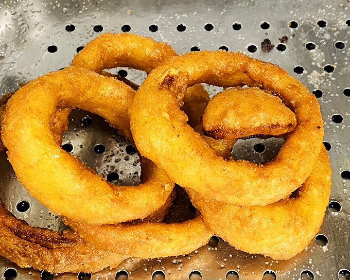 Golden halos of deep-fried perfection. These onion rings achieve that mythical balance of crispy exterior and tender interior that makes grown adults giddy.