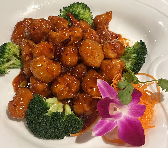 Orange Chicken that actually tastes like oranges&mdash;what a concept! Crispy, tangy, and adorned with an orchid that's basically saying, "You're welcome."