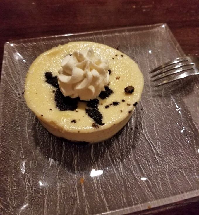 A dessert that whispers "you've earned this" after a long week. Creamy cheesecake with what appears to be chocolate crumbles&mdash;simple perfection on a glass plate.