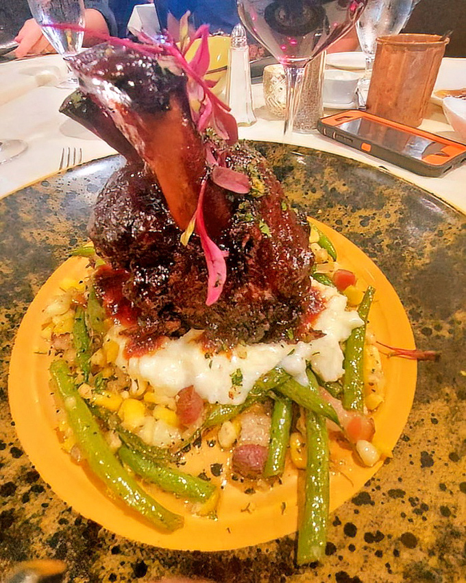 The Osso Buco rises from its bed of creamy grits and vegetables like a meaty skyscraper – architecture you can eat with a dramatic presentation worthy of Broadway.
