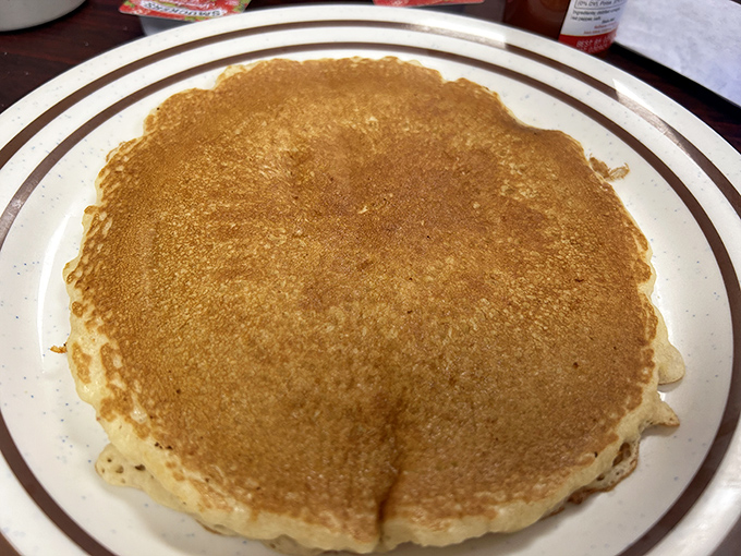 This golden-brown pancake isn't just breakfast&mdash;it's an edible security blanket, perfectly sized to cover the plate and your morning hunger pangs.
